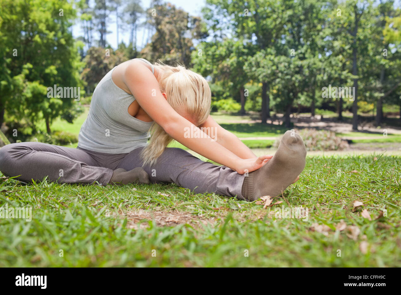 Sportswoman stretching on the lawn Stock Photo - Alamy
