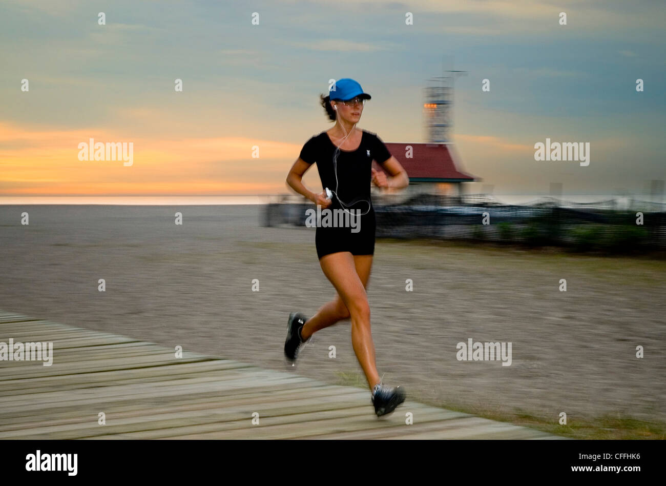Woman Running on Boardwalk at Sunrise Stock Photo - Alamy