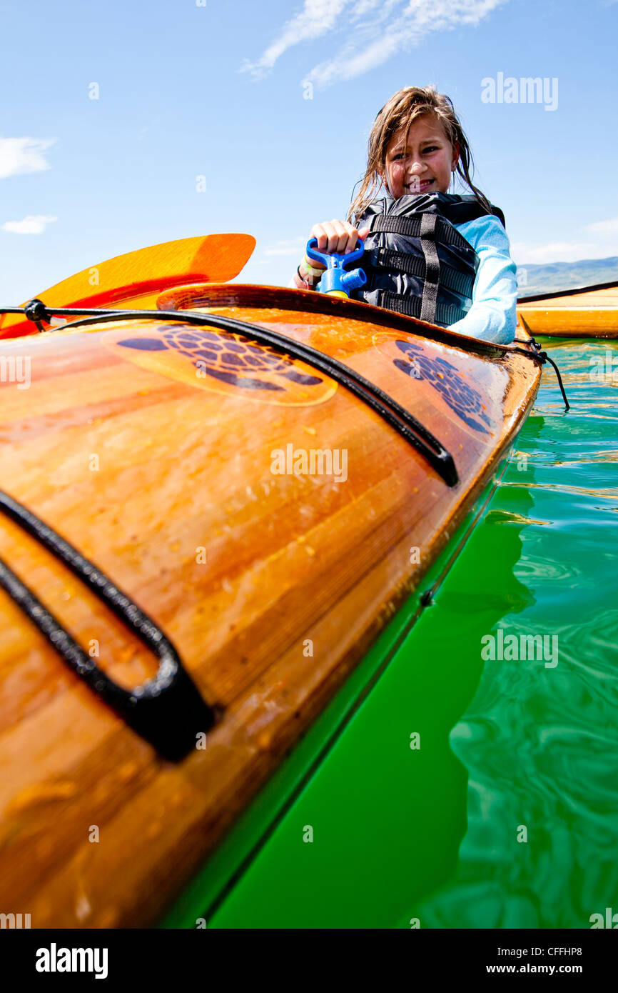 A woman sits in the wooden kayak with sea turtles as it is attached to ...