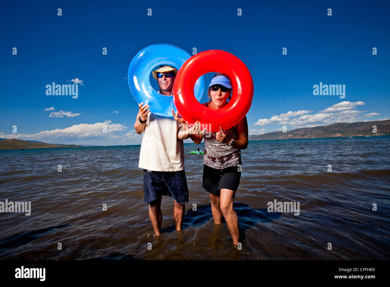 A man and a woman stand with a red and blue inner tube for portraits on ...