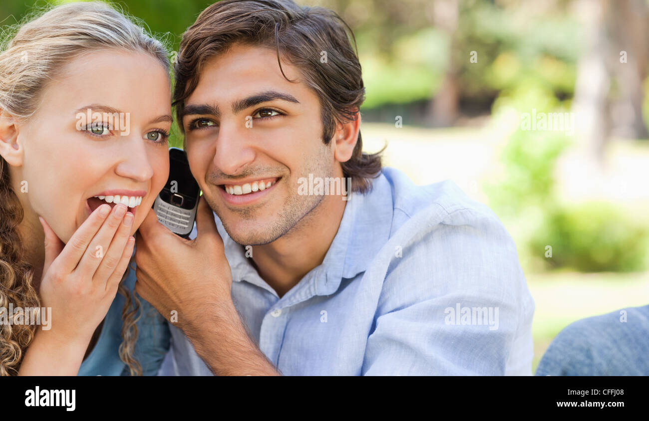 Curious couple in the park using a cellphone together Stock Photo - Alamy