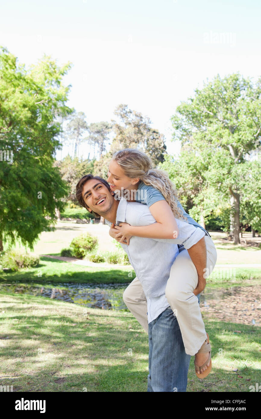 Side view of smiling man carrying his girlfriend on his back Stock ...