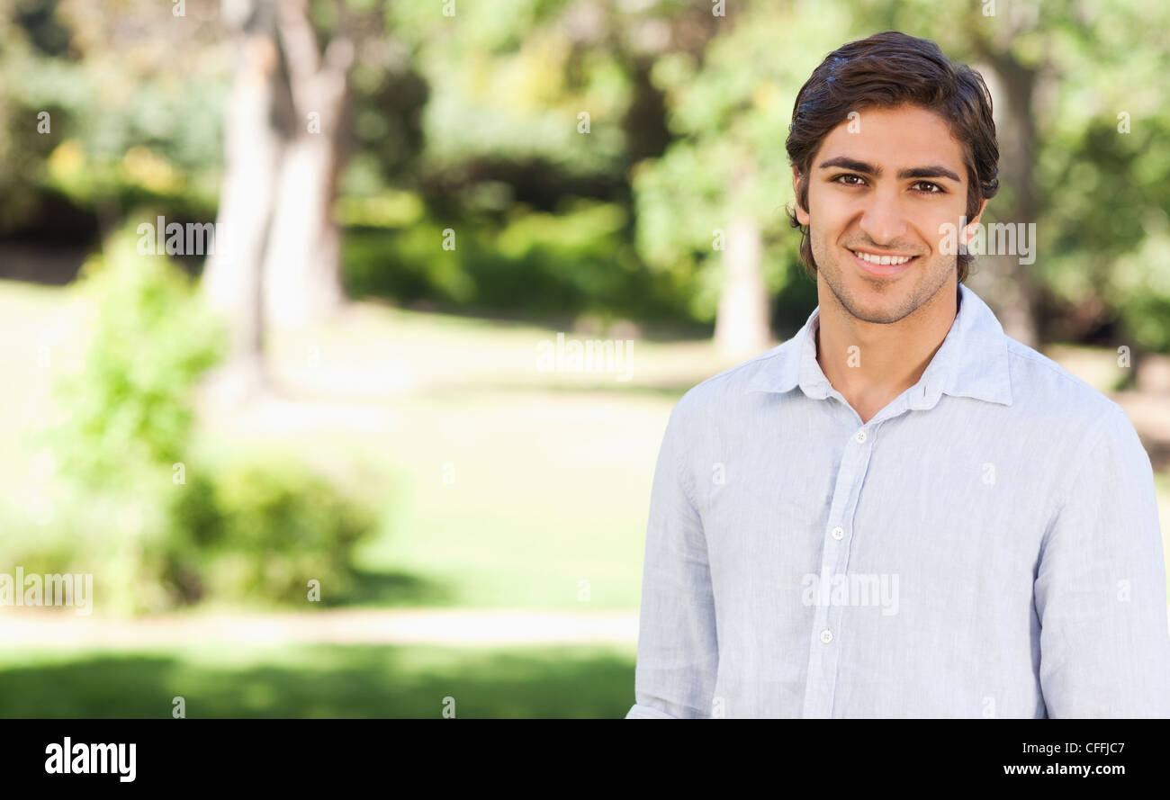 Smiling man standing in the park Stock Photo - Alamy