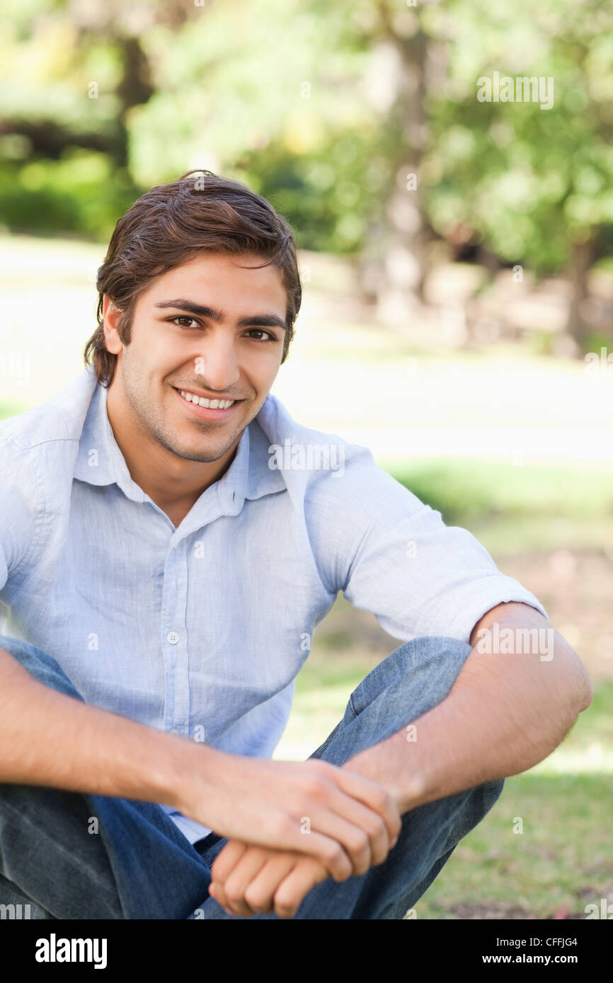 Smiling man sitting in the park Stock Photo - Alamy