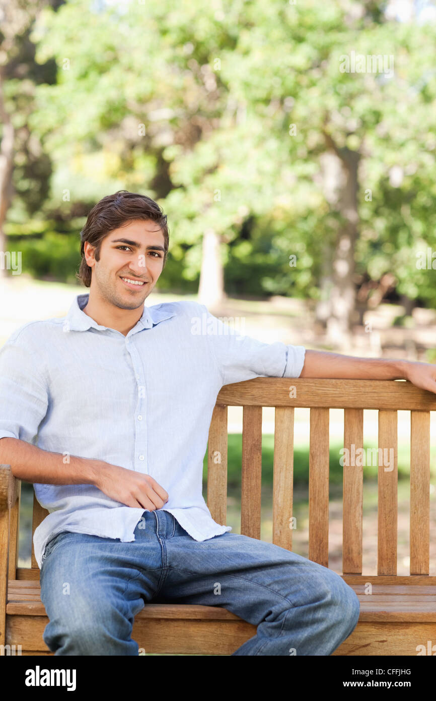 Smiling man sitting on a park bench Stock Photo - Alamy