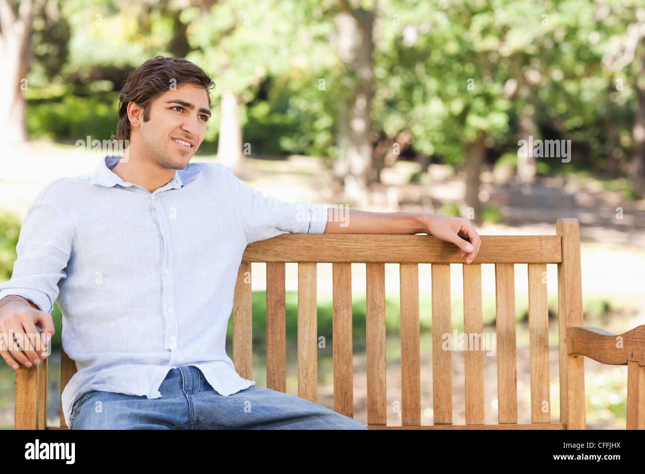 Man sitting on a bench in the park Stock Photo - Alamy