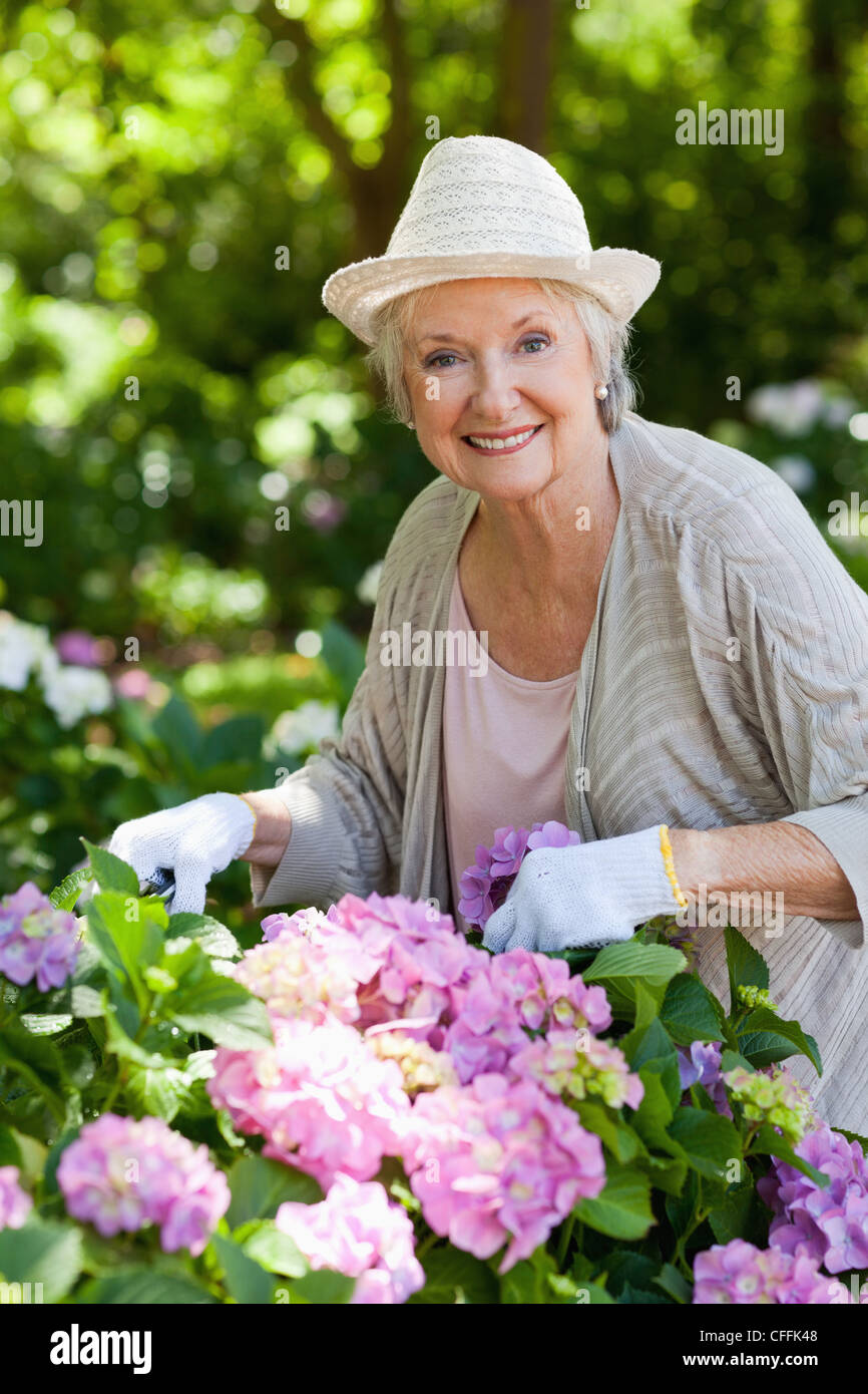 Woman smiling while pruning flowers Stock Photo - Alamy