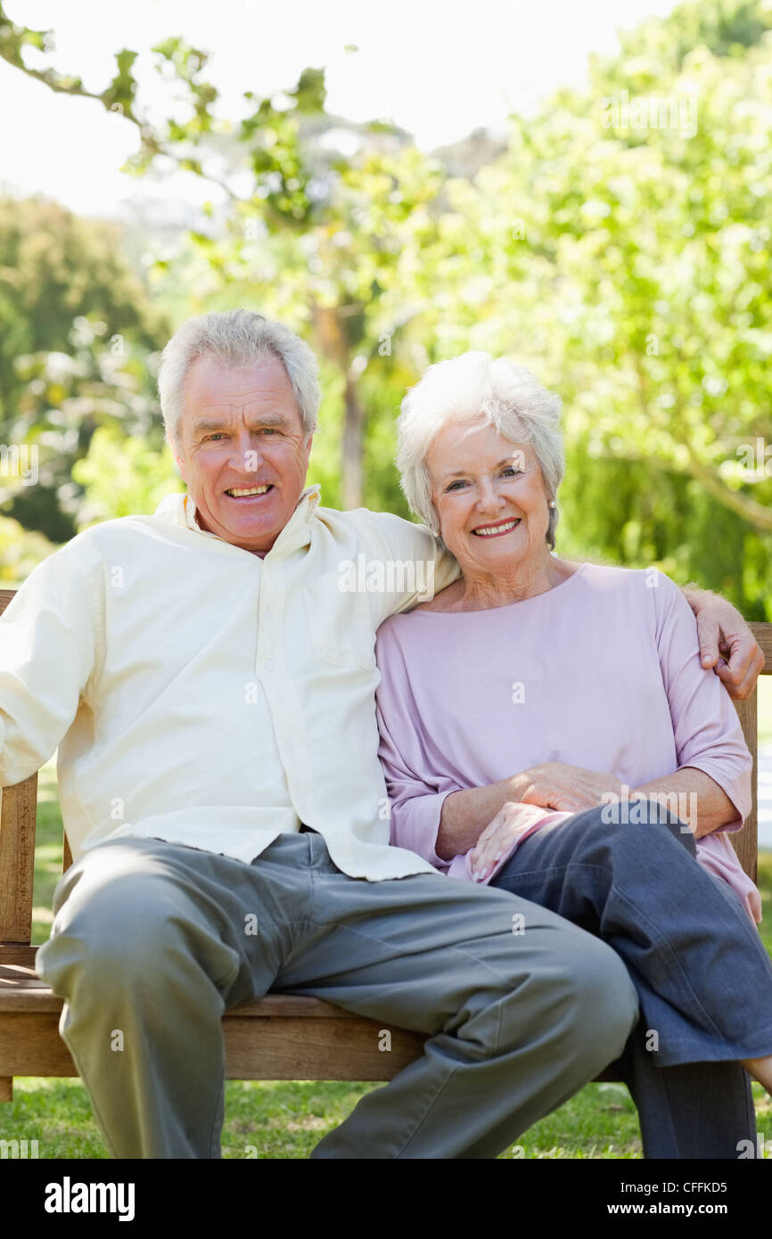 Tow friends smiling as they sit together on a park bench Stock Photo ...