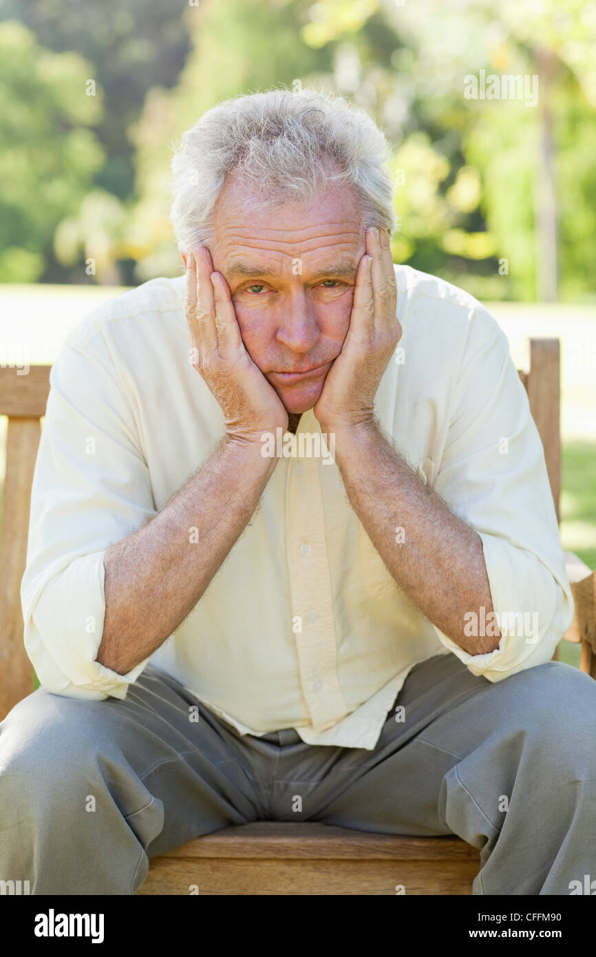 Disappointed man sitting on a bench Stock Photo - Alamy