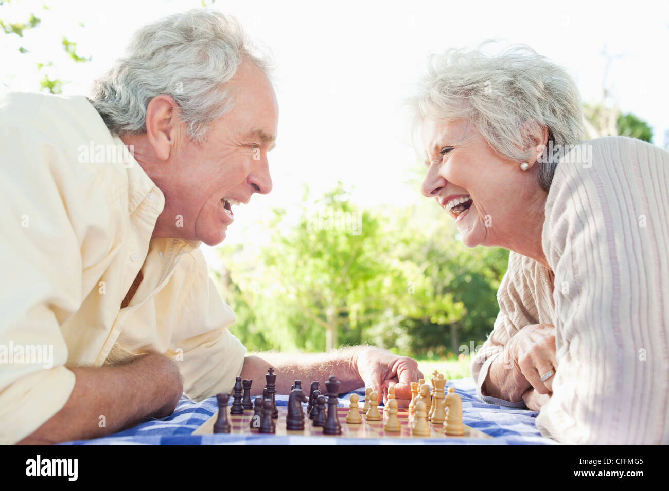 Two friends laughing while playing chess Stock Photo - Alamy