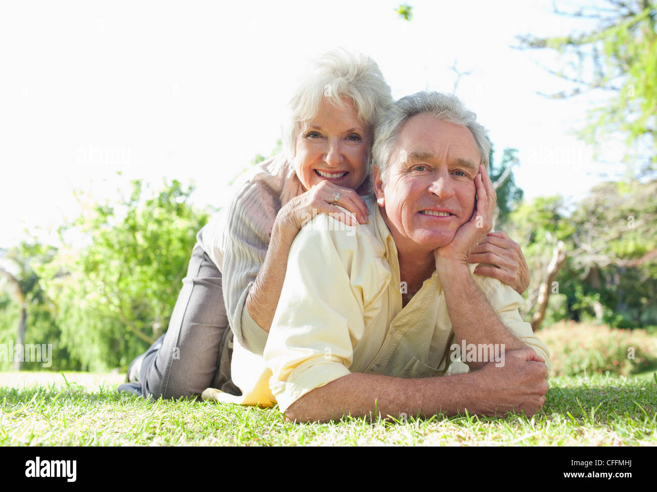 Woman playfully lying on top of a man while holding his shoulders Stock ...