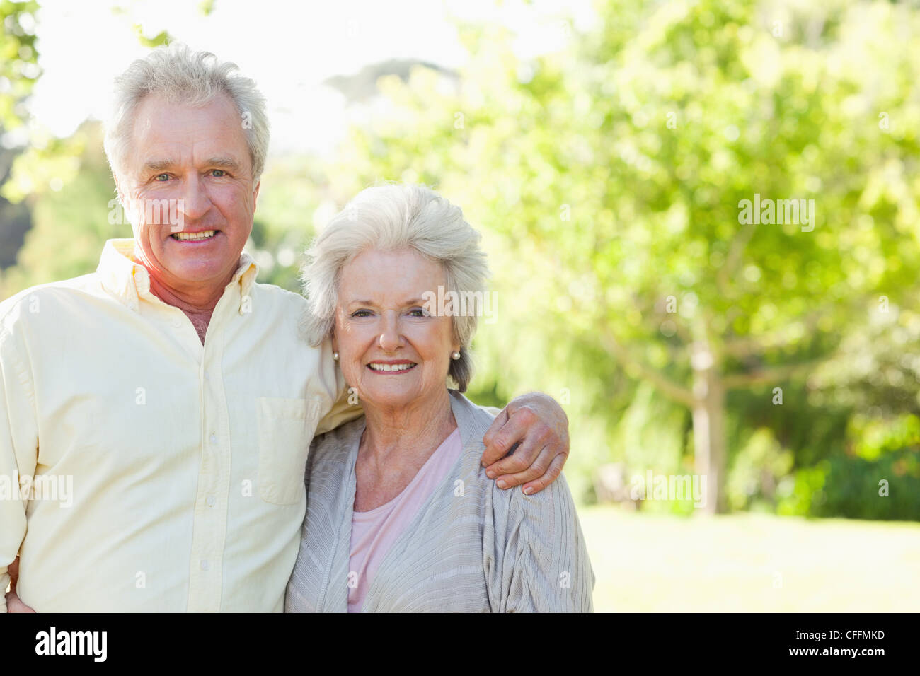 Man smiling as he puts his arm around his friend Stock Photo - Alamy