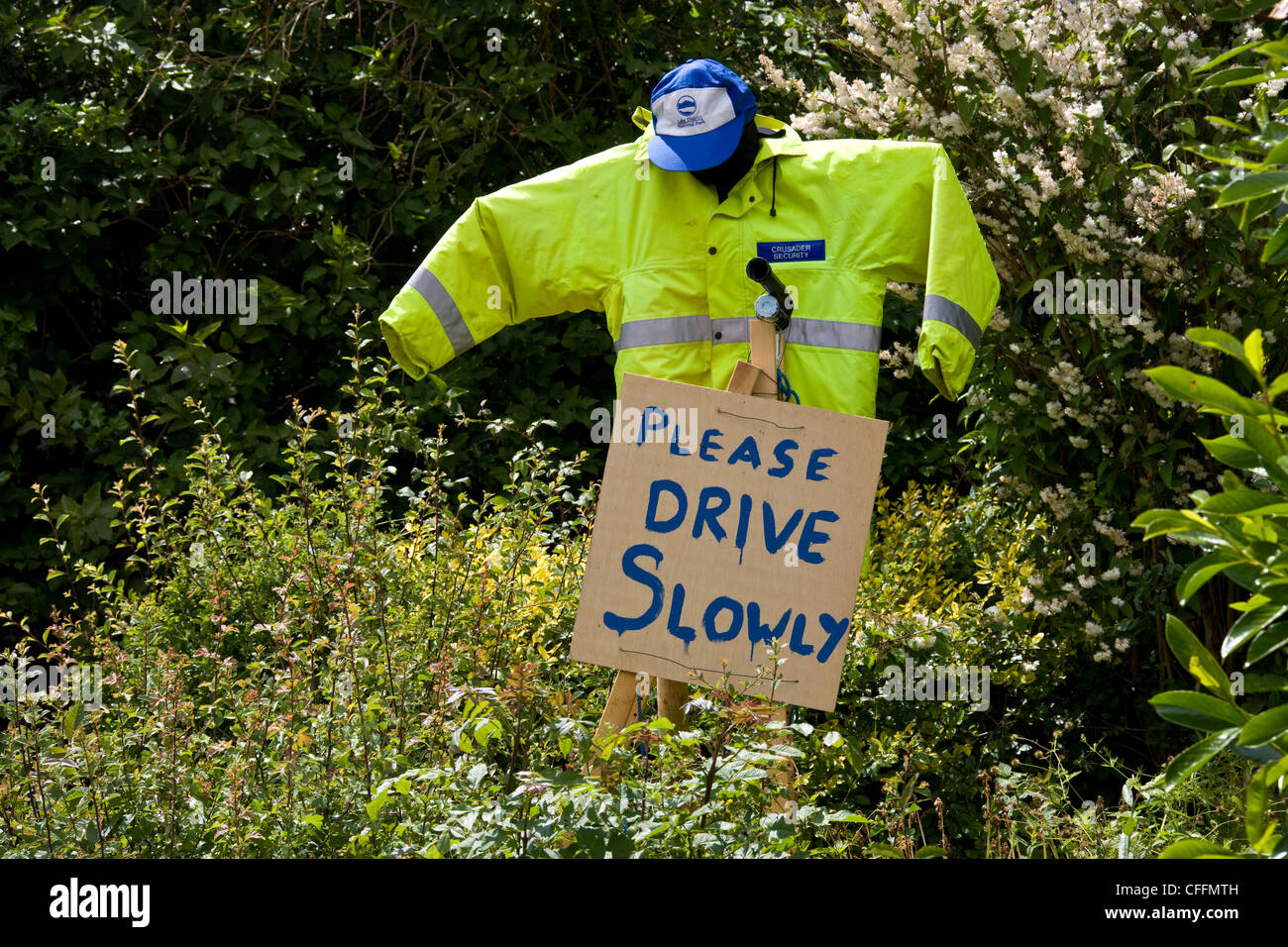 Fake Policeman with a please drive slowly sign in a village Stock Photo ...