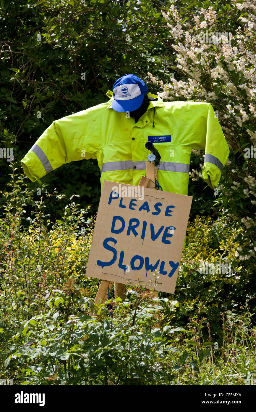 Fake Policeman with a please drive slowly sign in a village Stock Photo ...