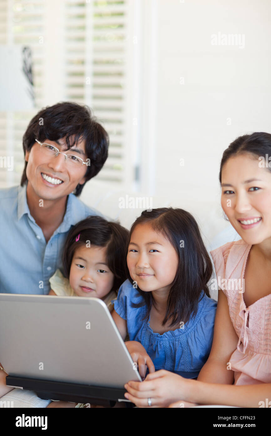 Happy family using the laptop together and looking forward Stock Photo ...