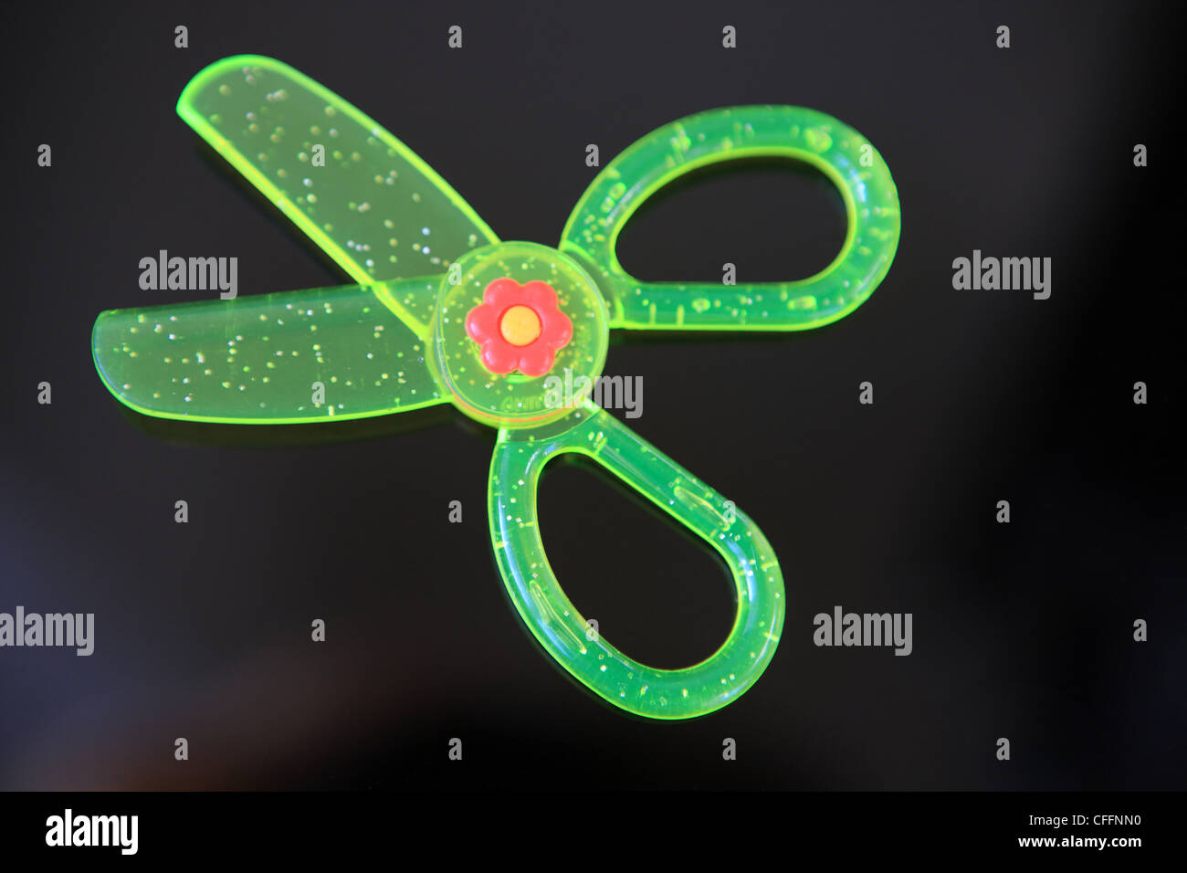 A pair of green children's scissors on a black background Stock Photo ...