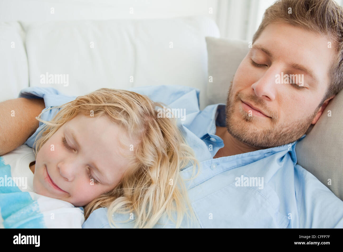 Close up of a boy and his father asleep on the couch Stock Photo - Alamy