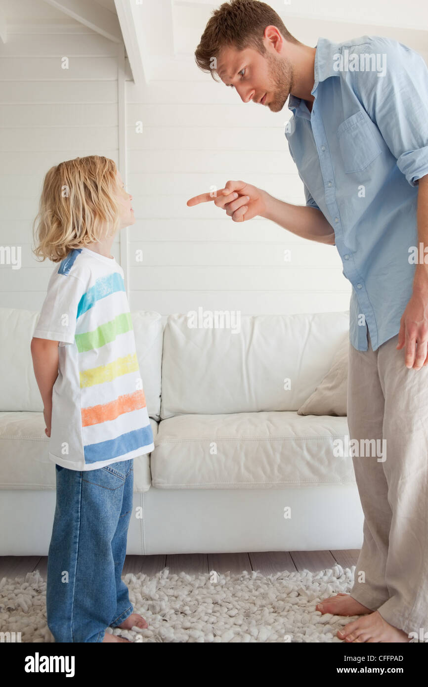 A father pointing to his son as he corrects him for doing something bad ...