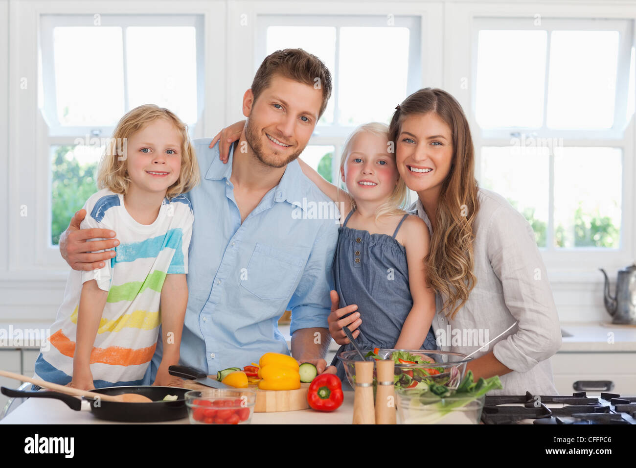 A happy family in the kitchen ready to make dinner Stock Photo - Alamy