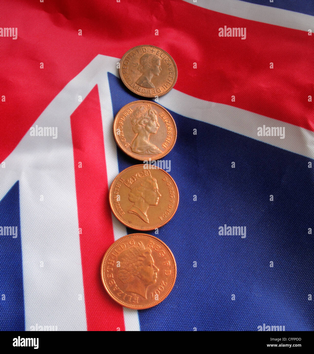 Four copper coins set against a union jack flag , showing the queens ...