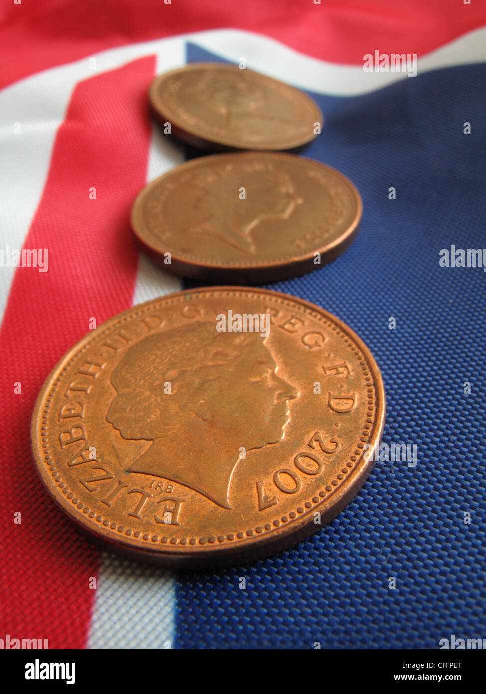 Three copper coins set against a union jack flag , showing the queens ...
