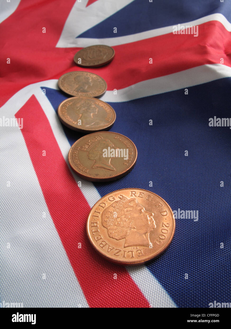 Five copper coins set against a union jack flag , showing the queens ...