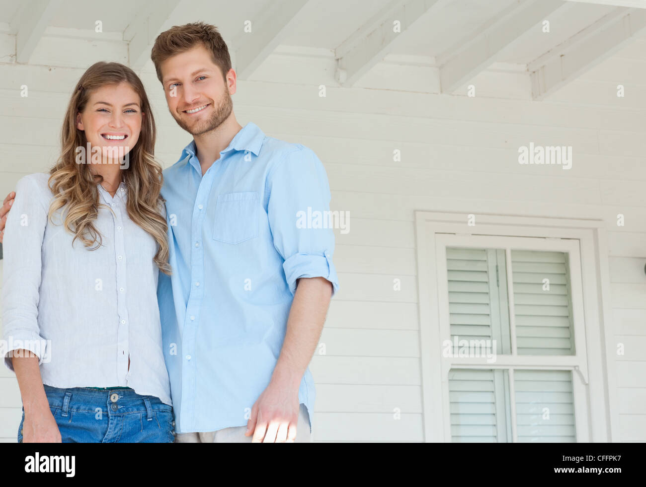 A loving couple embrace as they stand outside and look forward Stock ...