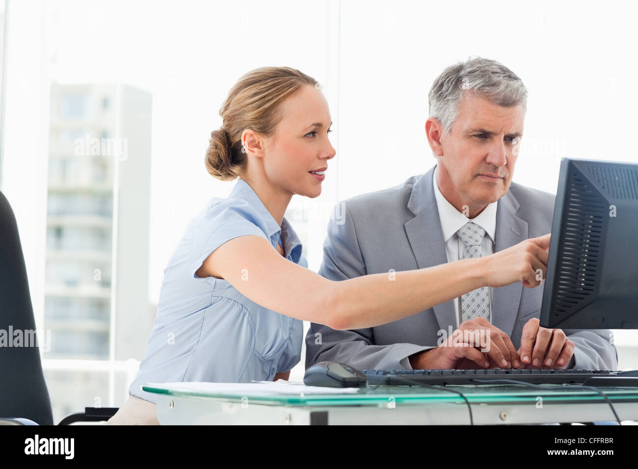 Boss watching his screen with his secretary Stock Photo - Alamy