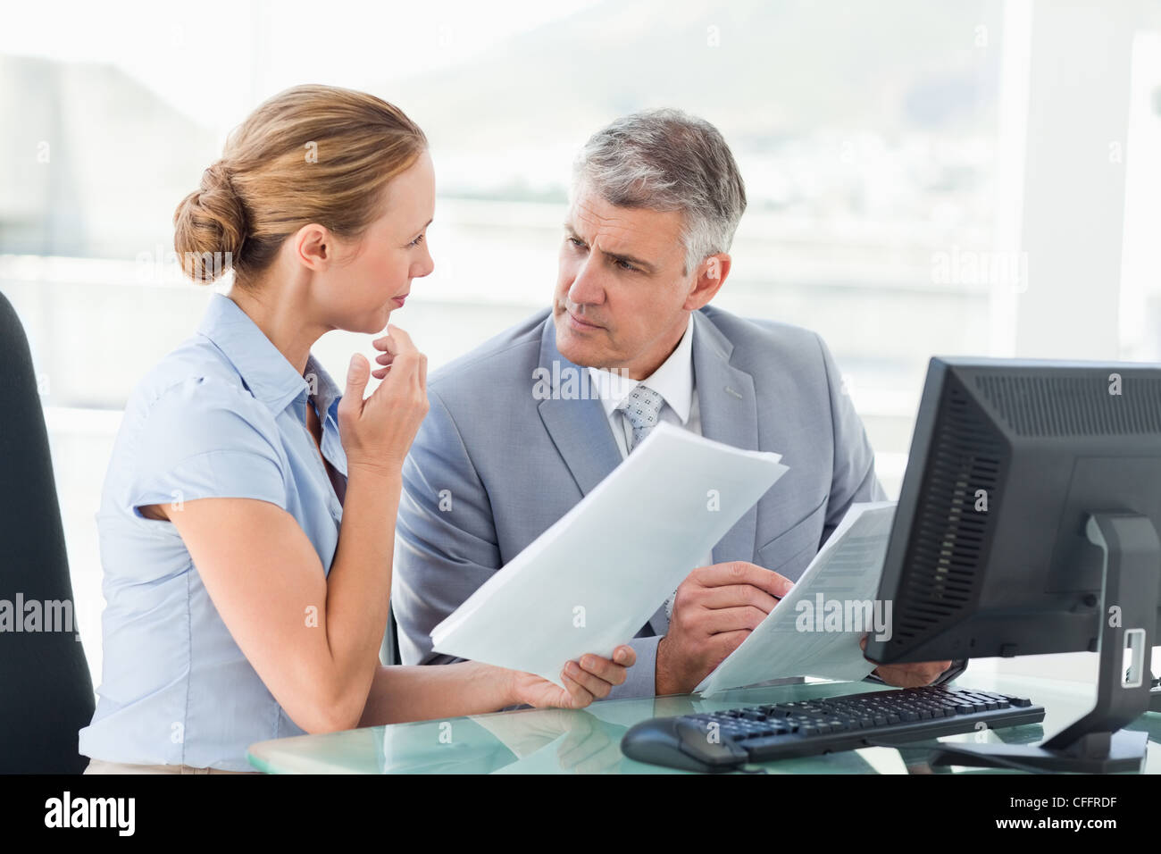 Boss talking about files to his employee Stock Photo - Alamy