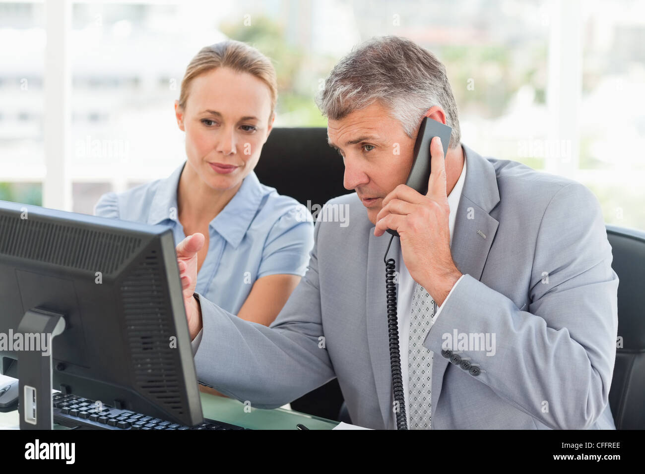 Boss on the phone while an employee is next to him Stock Photo - Alamy
