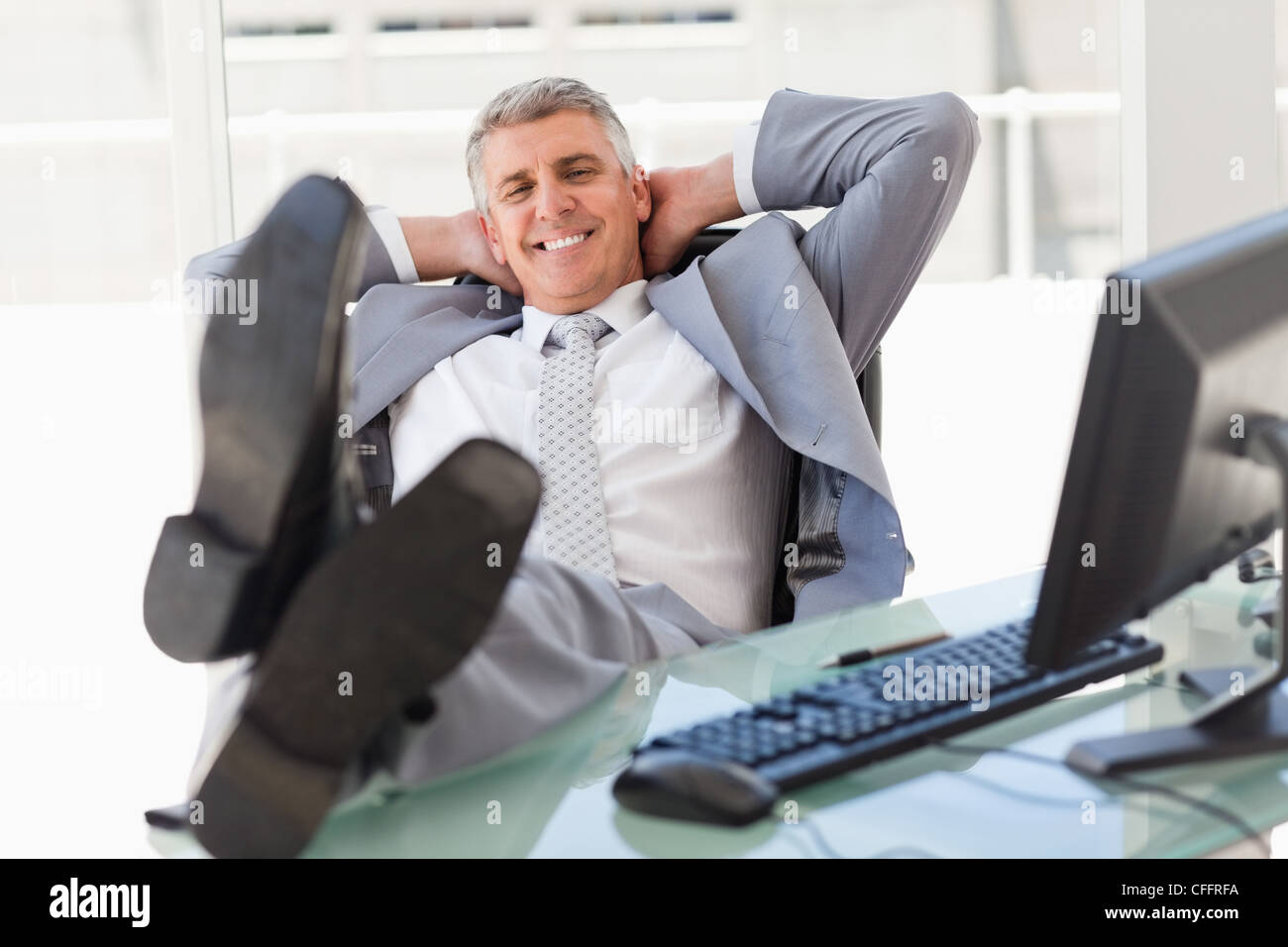 Happy boss with feet on his desk Stock Photo - Alamy