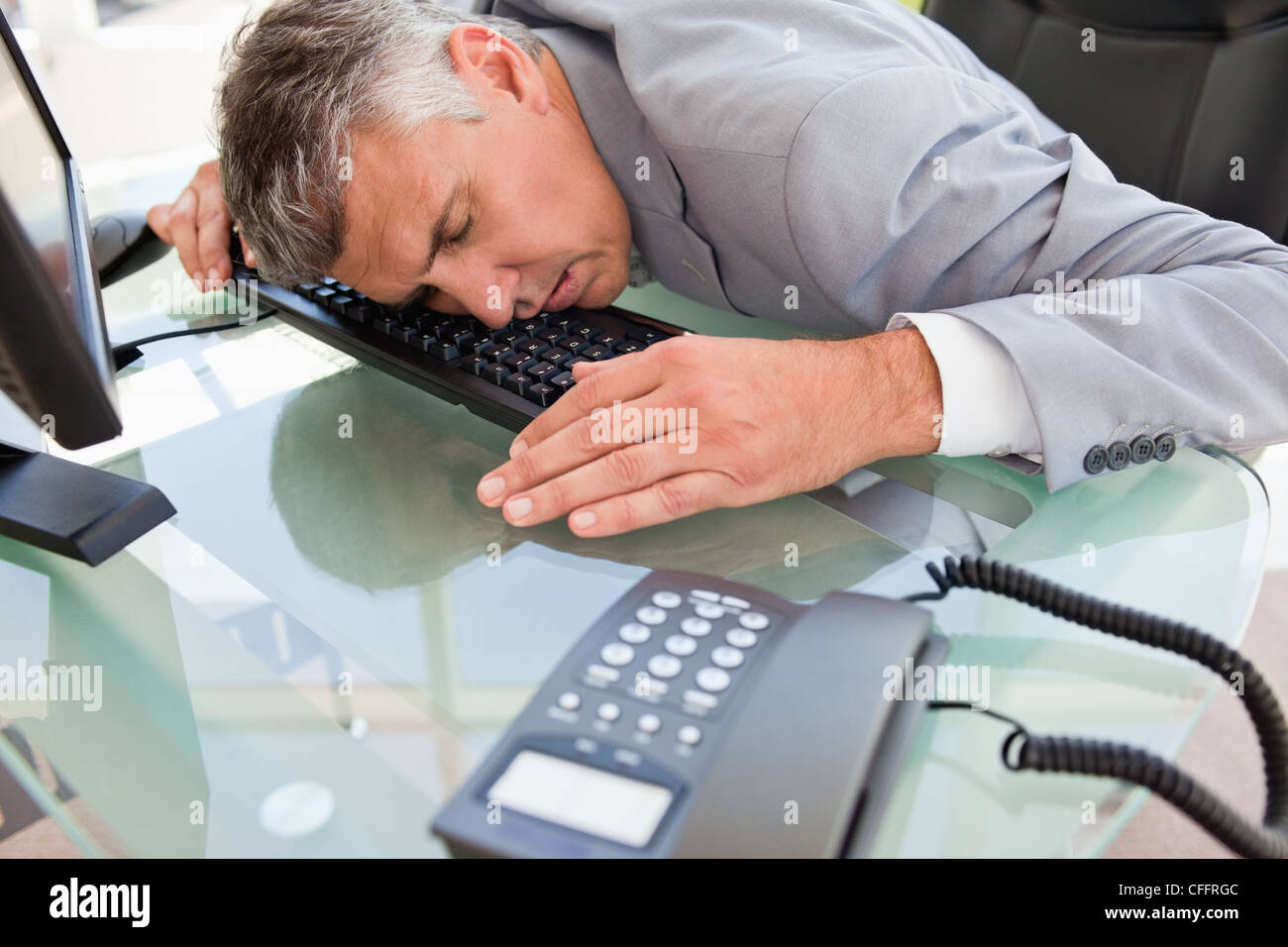 Businessman sleeping on his keyboard Stock Photo - Alamy