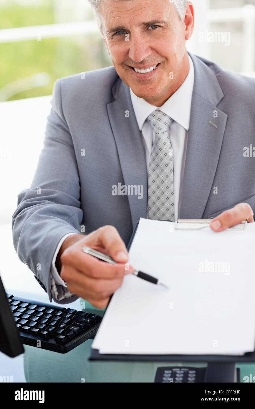 Portrait of a boss showing a file Stock Photo - Alamy