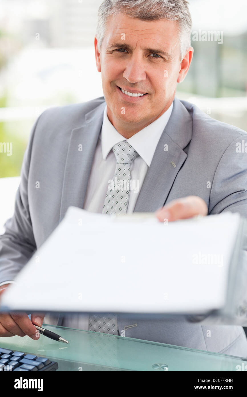 Portrait of a boss giving a file Stock Photo - Alamy