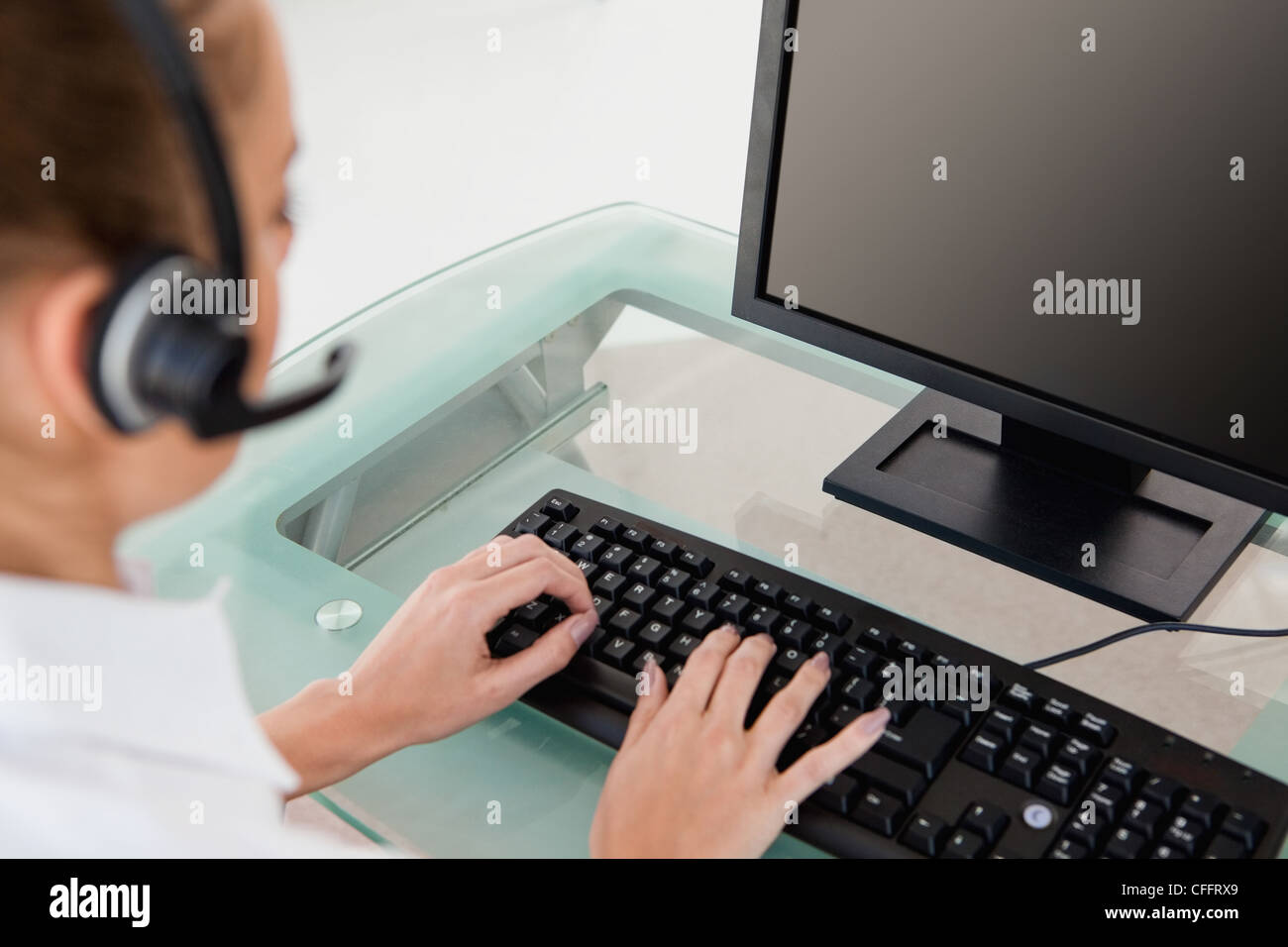 Rear view of a businesswoman using a computer with headset Stock Photo ...