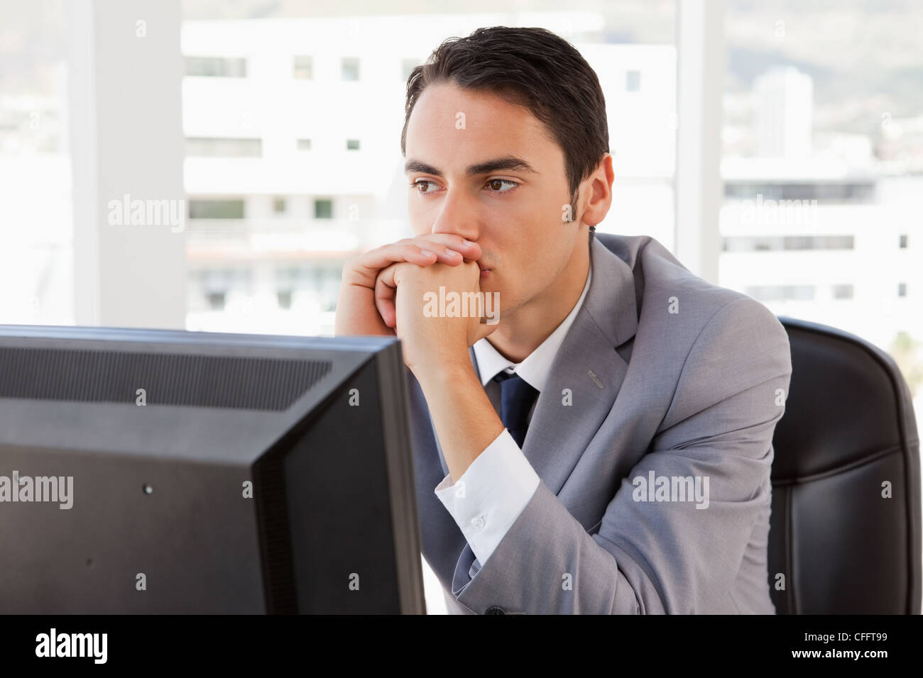 Businessman thinking in front of his computer Stock Photo - Alamy