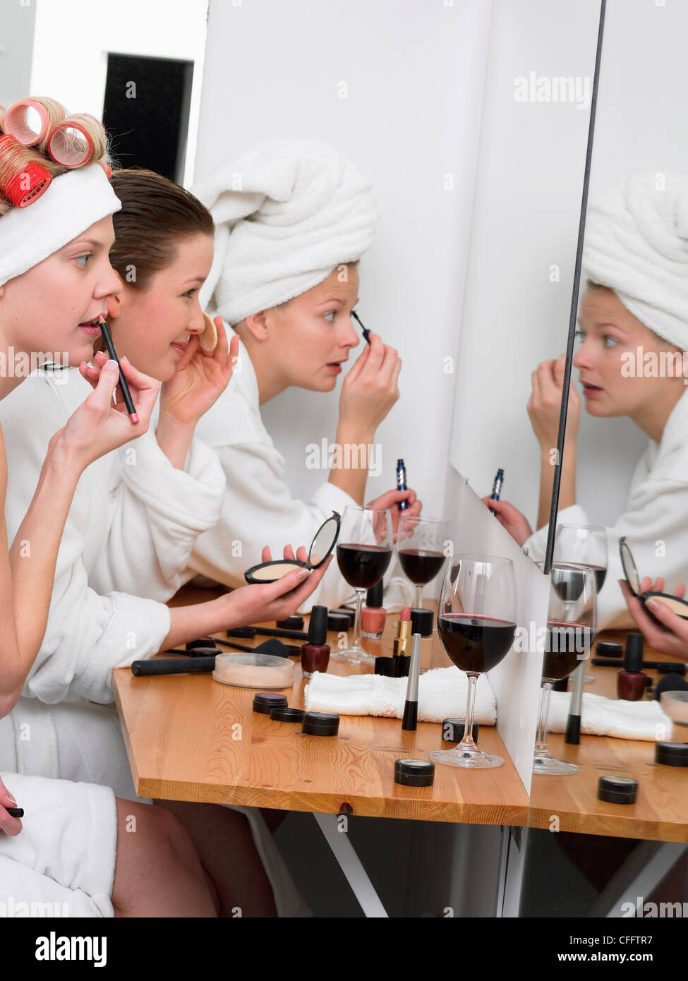 Women applying Make Up in Mirror Stock Photo - Alamy