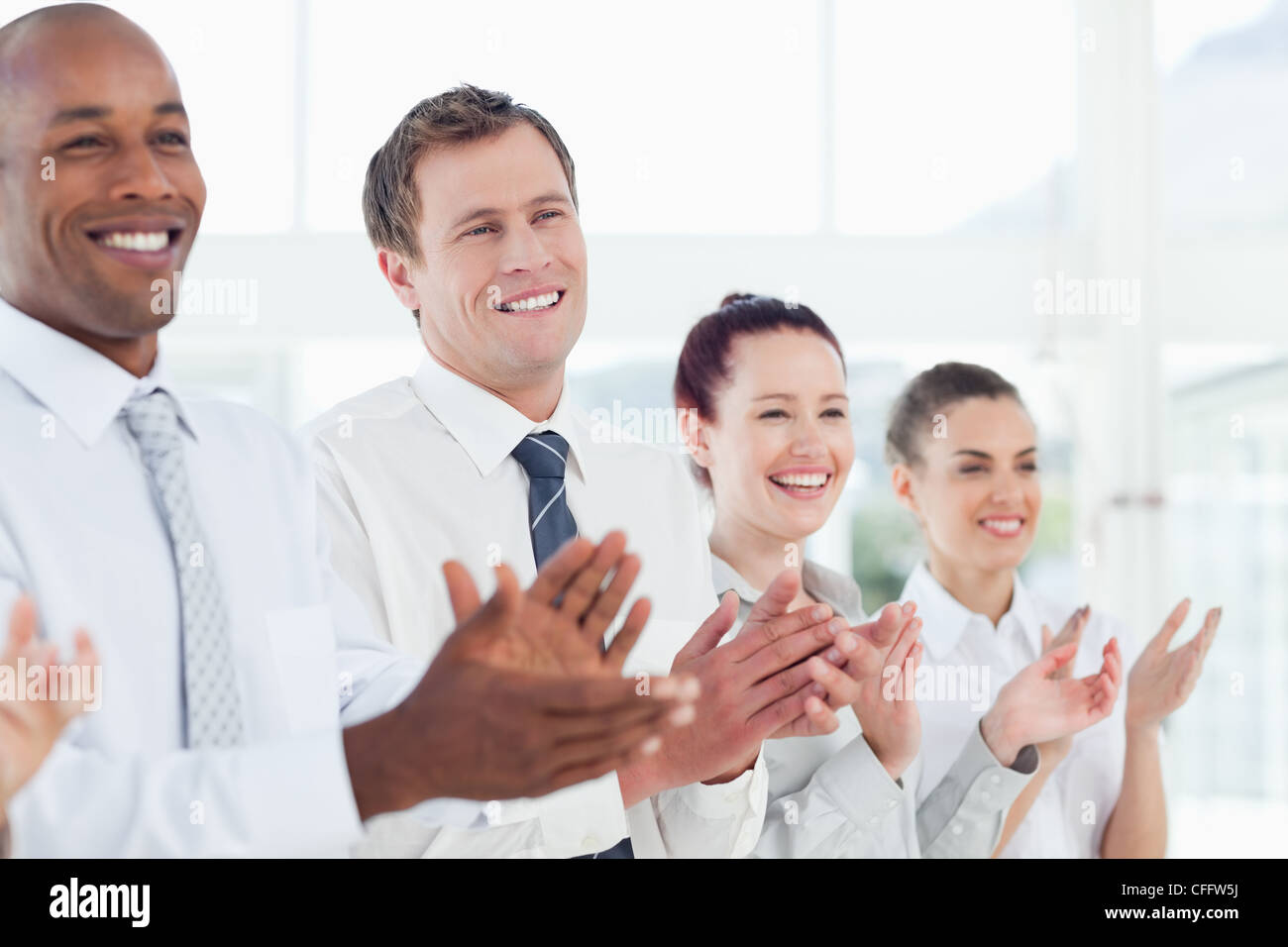Smiling salesteam giving applause Stock Photo - Alamy