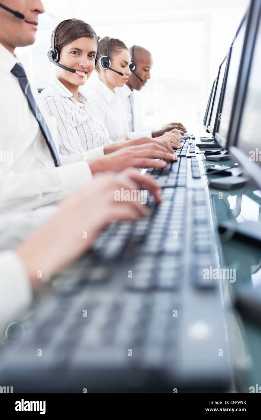 Smiling call center employee sitting among her colleagues Stock Photo ...