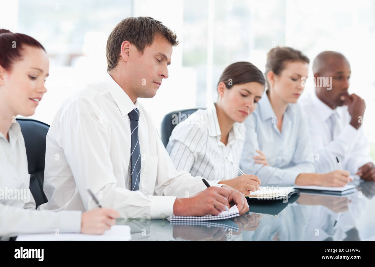 Businesspeople taking notes during a meeting Stock Photo - Alamy
