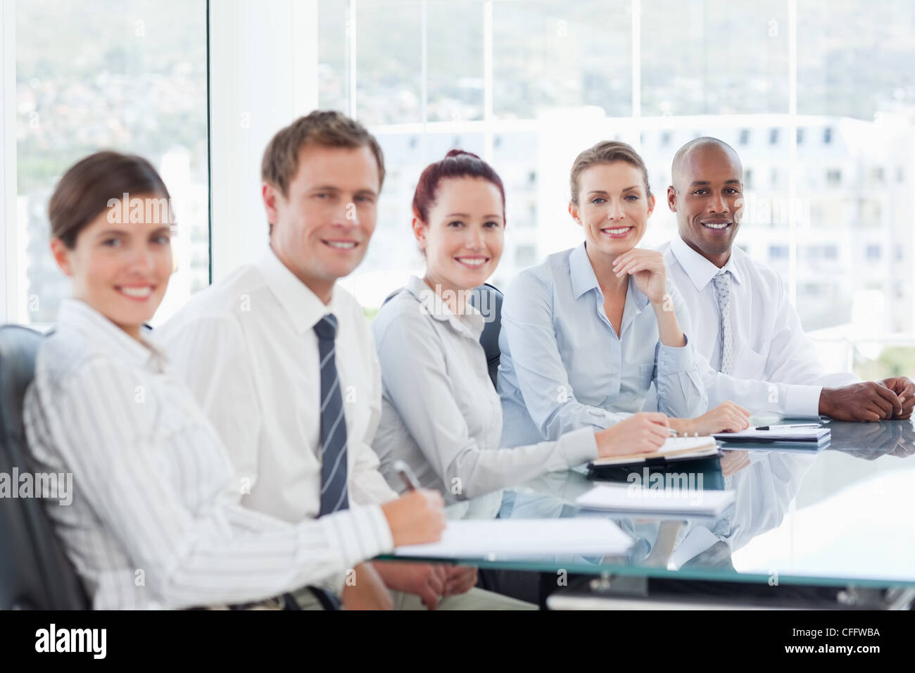Side view of smiling businesspeople sitting at a table Stock Photo - Alamy Side view of smiling businesspeople sitting at a table Stock Photo - Alamy