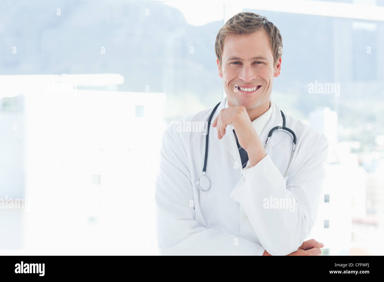 Smiling doctor standing next to a window Stock Photo - Alamy
