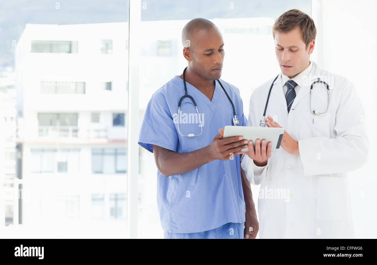 Standing doctors using tablet Stock Photo - Alamy