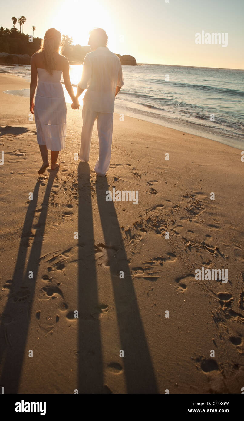 Sunset with lovers walking on the beach Stock Photo - Alamy