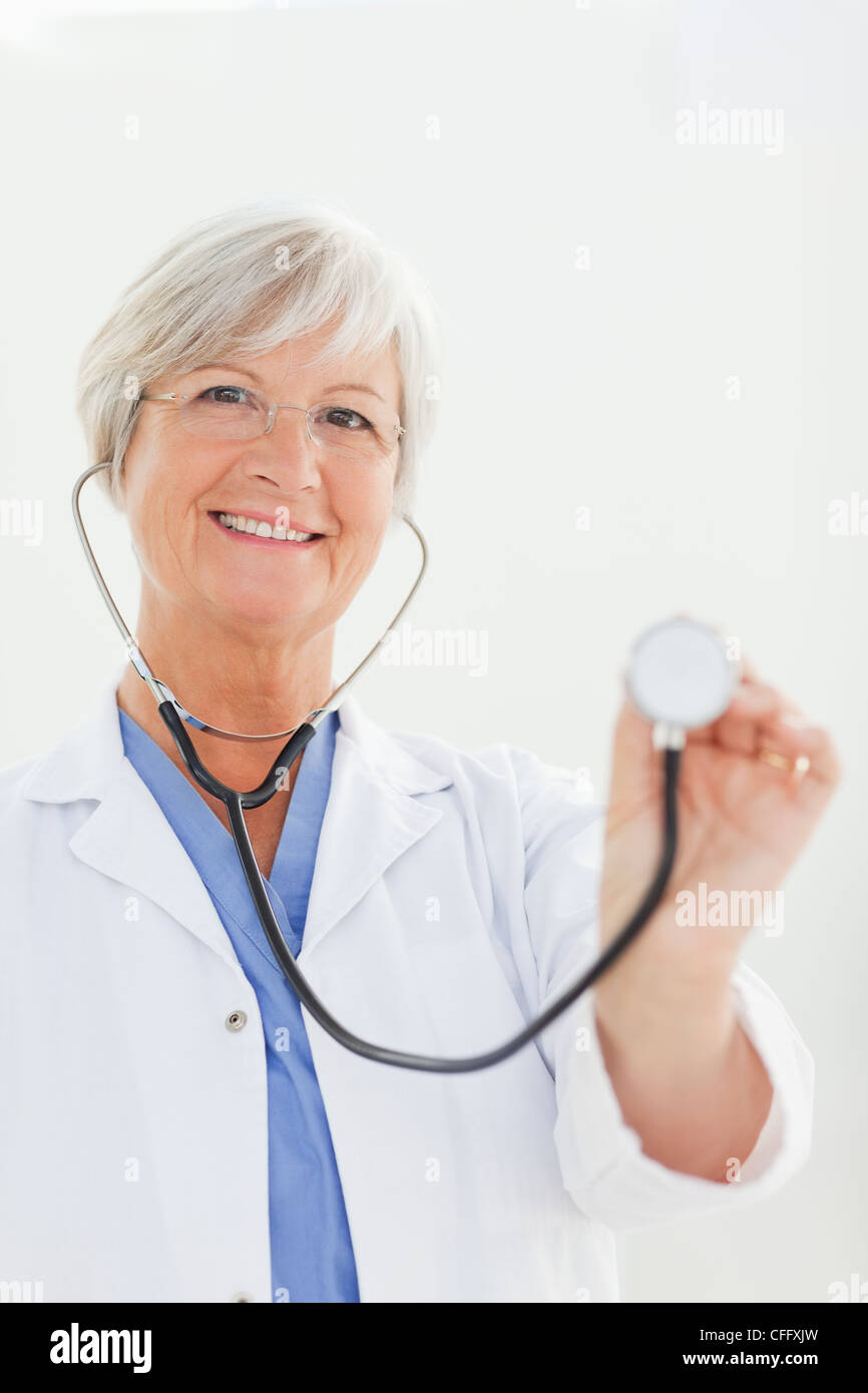 Smiling doctor using her stethoscope Stock Photo - Alamy
