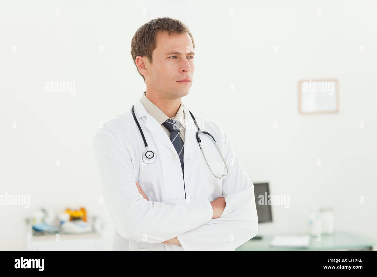 Doctor with arms folded in his examination room Stock Photo - Alamy