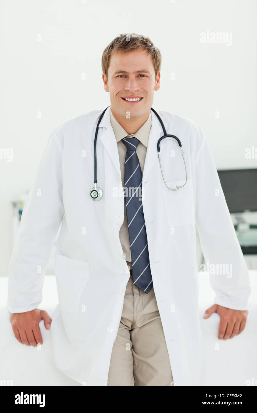 Smiling doctor standing in his examination room Stock Photo - Alamy