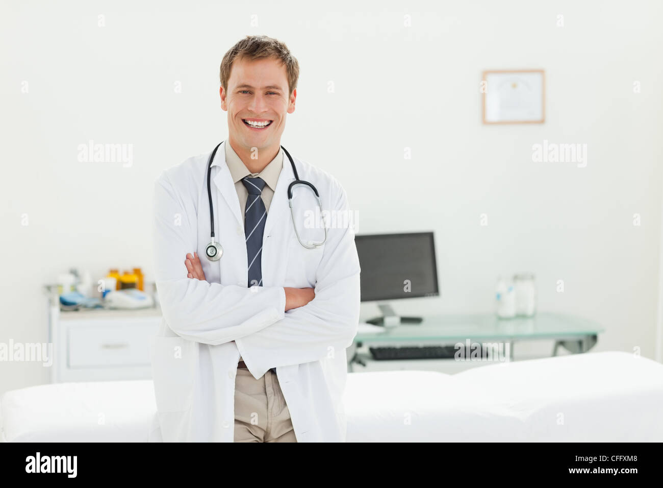 Smiling doctor with his arms folded in his examination room Stock Photo ...