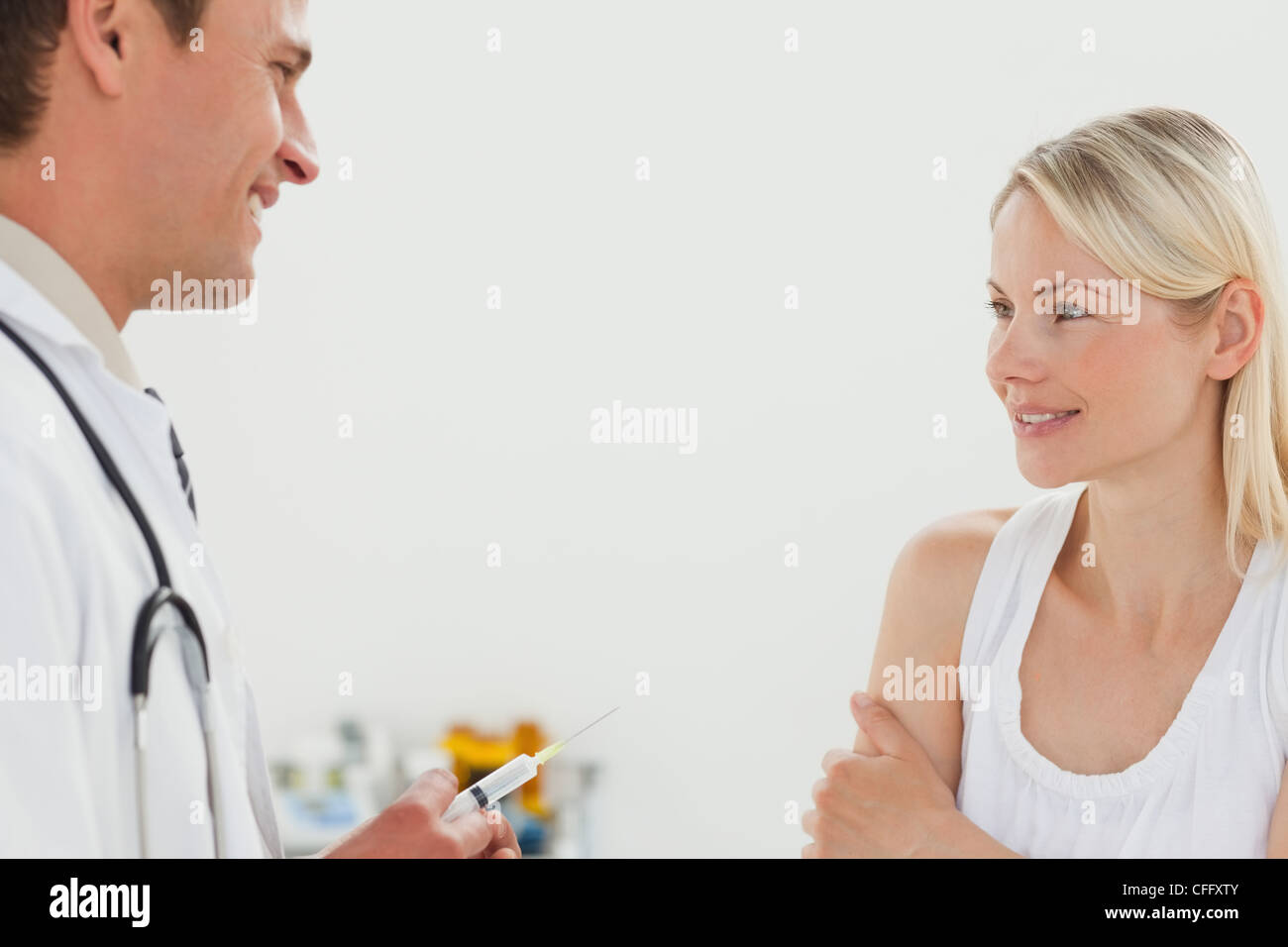 Smiling doctor with syringe talking with his patient Stock Photo - Alamy