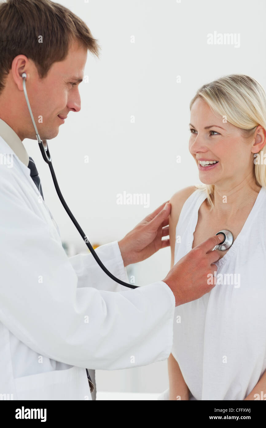 Smiling doctor checking his patients heart beat Stock Photo - Alamy